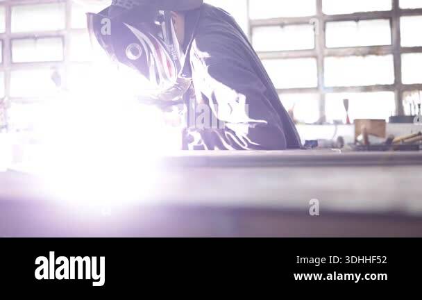 Professional welder in a protective mask and gloves welding a steel ...