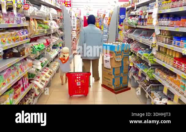 in a supermarket you can see from behind a woman and a small child ...