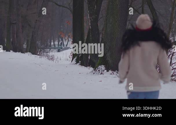 girl running on a snowy road in a winter park Stock Video Footage - Alamy