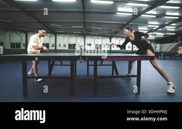 Young man and woman intensely playing a competitive game of table ...