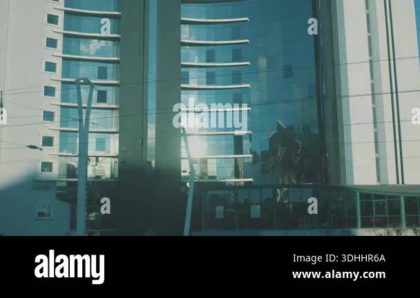 Sun flares reflecting on the glass windows of a modern office building ...