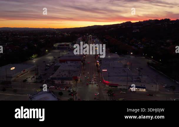 Aerial drone view of a main city street with evening traffic ...