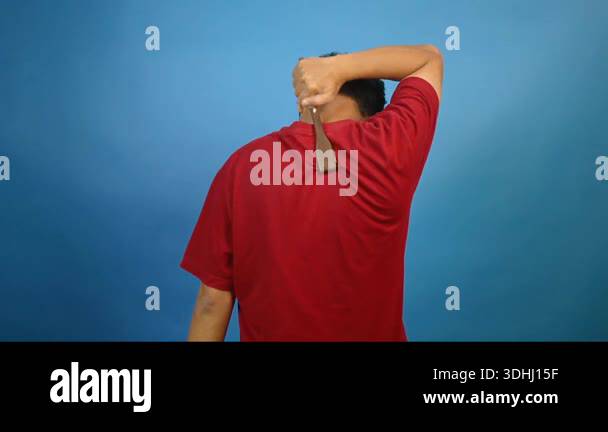 Asian man scratching itchy back with scratcher isolated on blue ...