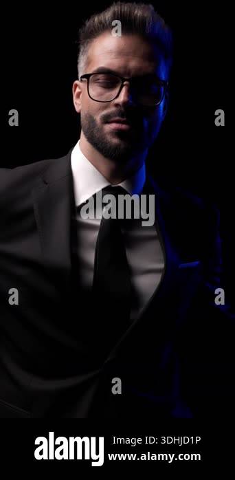 Elegant man in a suit and glasses looking around, buttoning his jacket ...