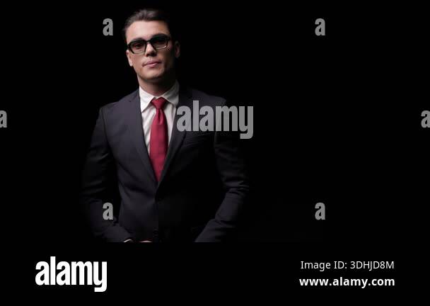 Fashion man in suit grabbing jacket, turning and clasping hands while ...