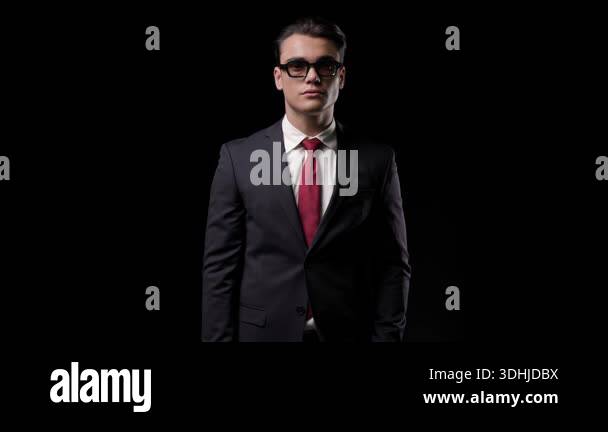 Elegant man in suit and glasses is buttoning jacket, adjusting suit ...