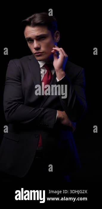 Handsome man touching cheek and neck, placing hands in pockets and ...