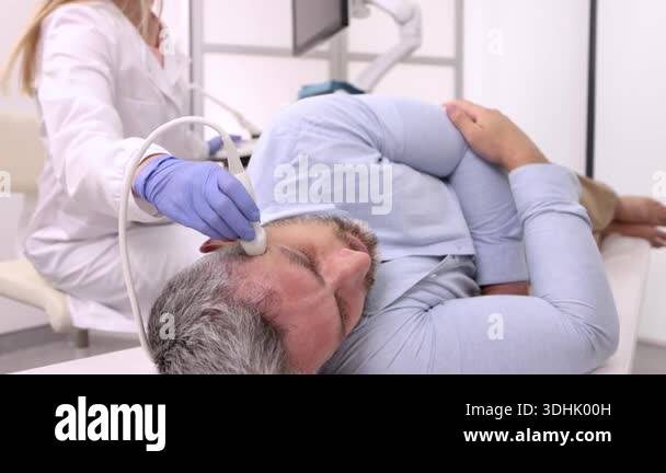 Sonographer examines brain of adult man by placing ultrasound ...