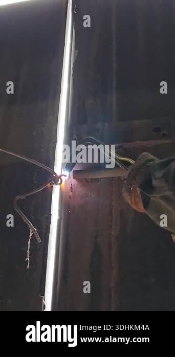 Slow motion footage of welder man welding metal beams in factory with ...