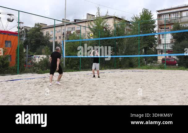 A man and a woman play beach volleyball on sand, a calm start of a long ...