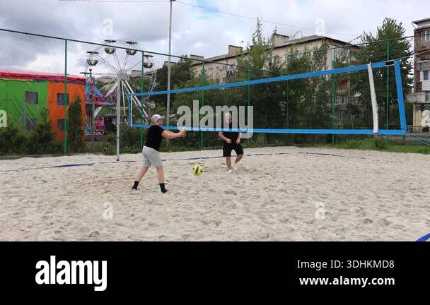 A man and a woman play beach volleyball on sand, a calm start of a long ...