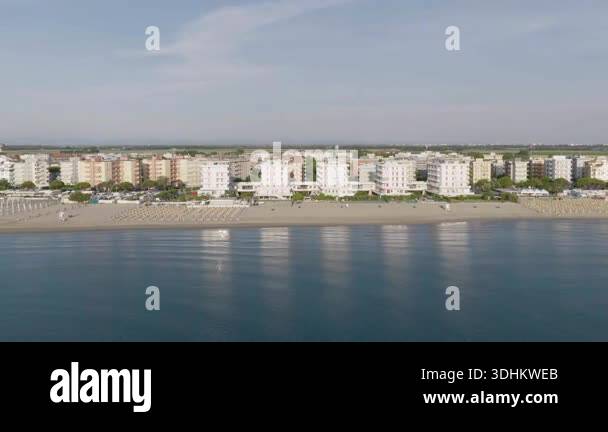 Drone view of sandy beach with umbrellas,gazebos and background town ...