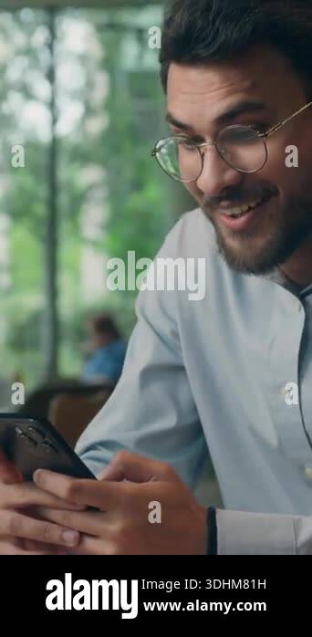 Indian smiling satisfied businessman using mobile phone app looking at ...