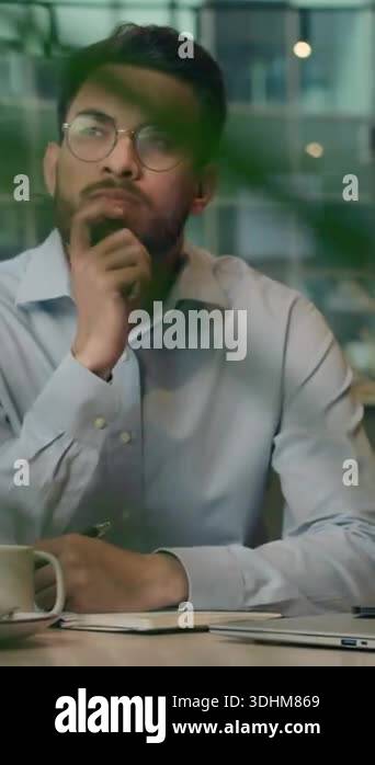 Ethnic Indian business man thinking come up with idea writing notes ...