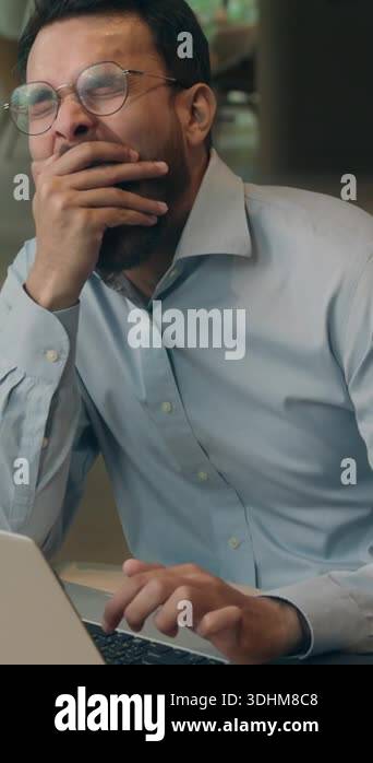 Unmotivated Muslim business man in cafe working laptop yawning typing ...