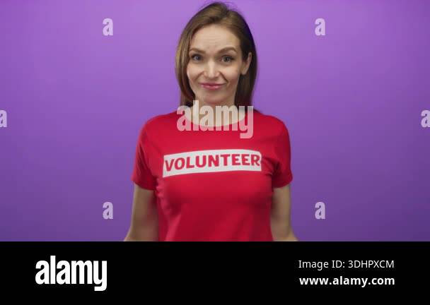 Young caucasian woman pointing finger to volunteer logo on red shirt in ...