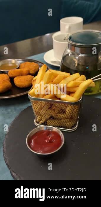 The man picks up a plate of nuggets and salad, then puts it back down ...