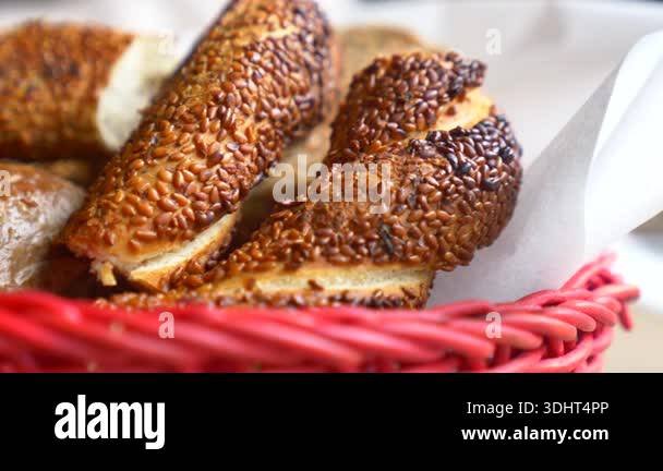 A basket holds warm bread rolls covered in sesame seeds Stock Video ...
