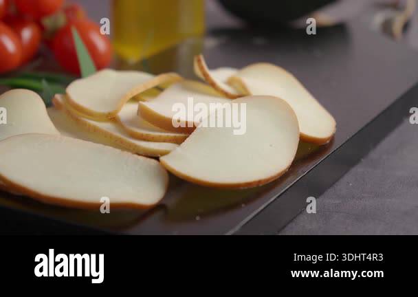Cheese slices lie on a cutting board with fresh tomatoes and oil Stock ...