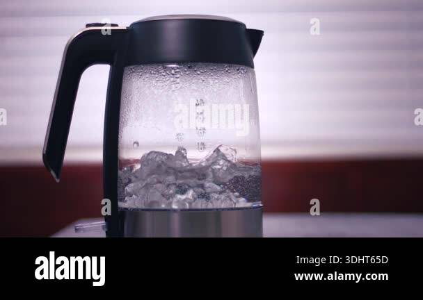 Hot water boiling in glass kettle medium 4k slow motion shot selective ...