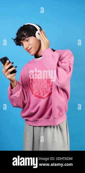 Stylish young man with headphones listening to music on his smartphone ...