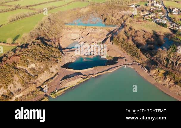 Aerial Shoreline Quarry With Blue Lagoon And Cliffs, Farmland Backdrop ...