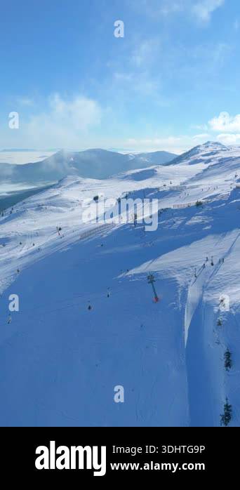 Vertical aerial view of alpine ski slopes with visible cold air vapor ...