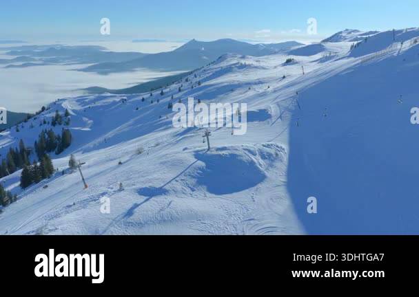 Morning aerial view of groomed ski slopes with chairlift before opening ...