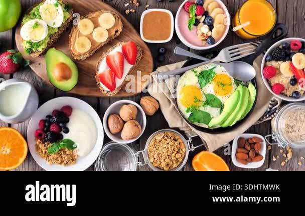 Healthy breakfast table scene with fruit, yogurts, oatmeal, smoothie ...