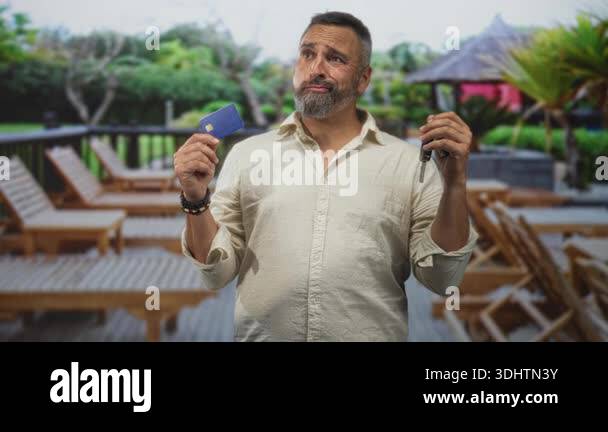 Man middleaged with beard holding creditcard and keys in building by ...