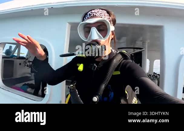 First person view of a female scuba diver in full gear jumping backward ...