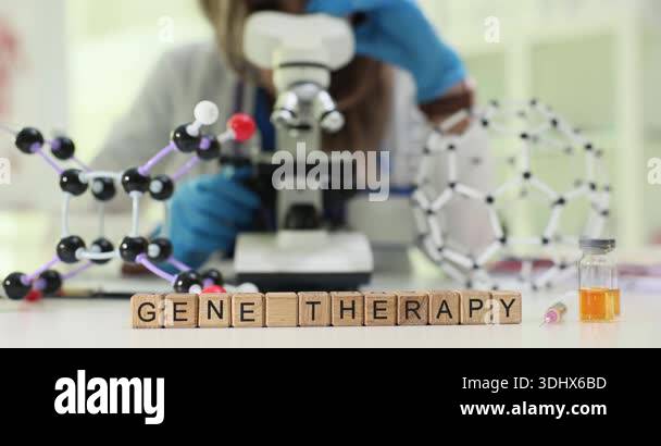 Wooden cubes spell words Gene Therapy near molecular models. Woman ...