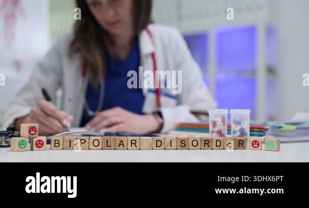 Text Bipolar Disorder on blocks and emojis on psychiatrist desk. Female ...