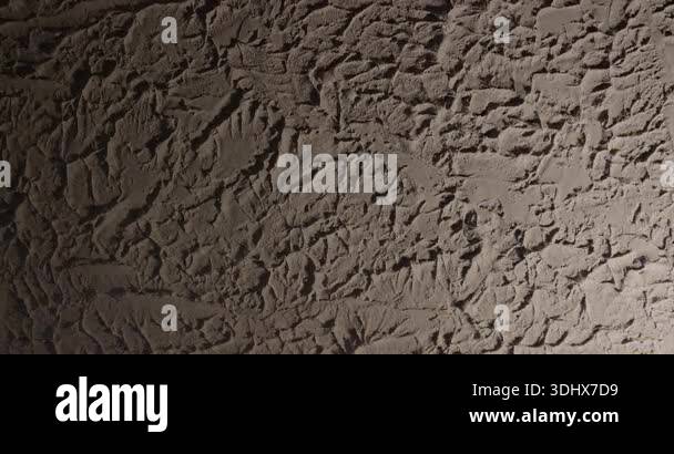 Rough bumpy wall texture casting shadows from moving spot light source ...