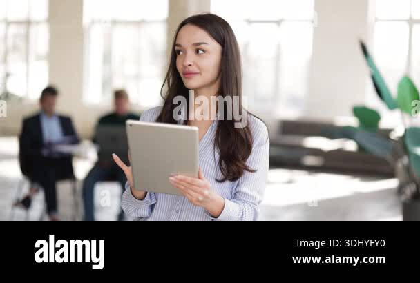 Focused young adult office employee working on digital tablet ...