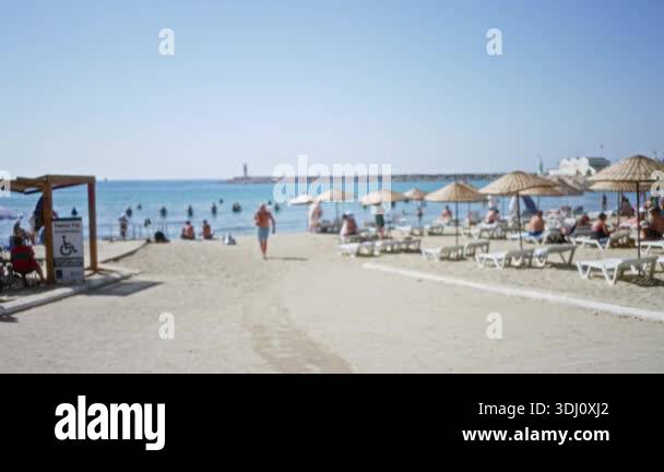 Blurred beach scene with soft bokeh, straw umbrellas and sun loungers ...