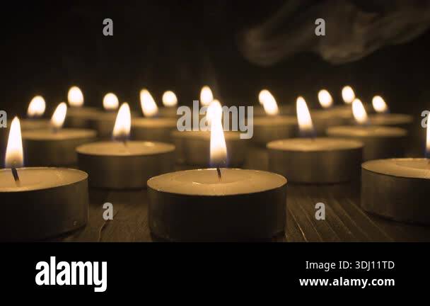 many burning memorial candles. Group of glowing candle lights in the ...