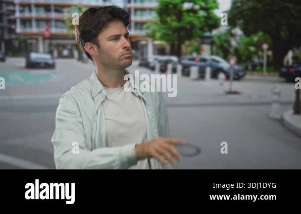 Young hispanic man with raised hands palm out on city street signaling ...