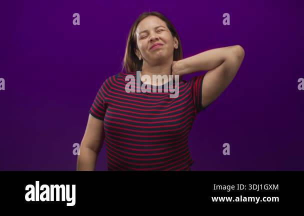 Woman holding neck with hand in purple studio, striped red navy shirt ...