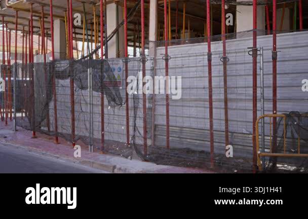 Construction site fence and scaffolding with corrugated metal panels ...