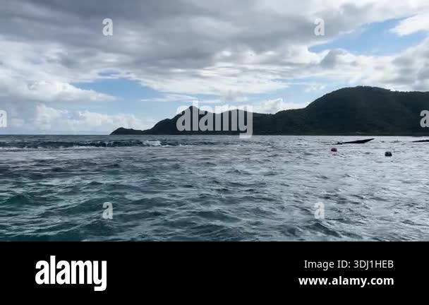 View from a moving boat of a Caribbean island with rocky reef and ...