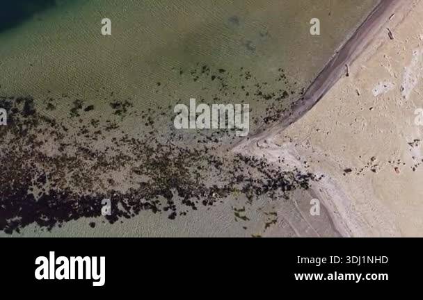This aerial scene captures a stunning coastal area where land meets ...