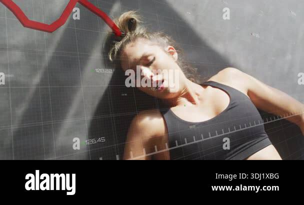 Female athlete lying on gym floor raising gloved hand defending against ...