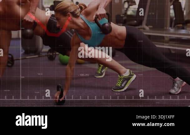 Fitness duo planking with kettlebells performing alternating rows as ...