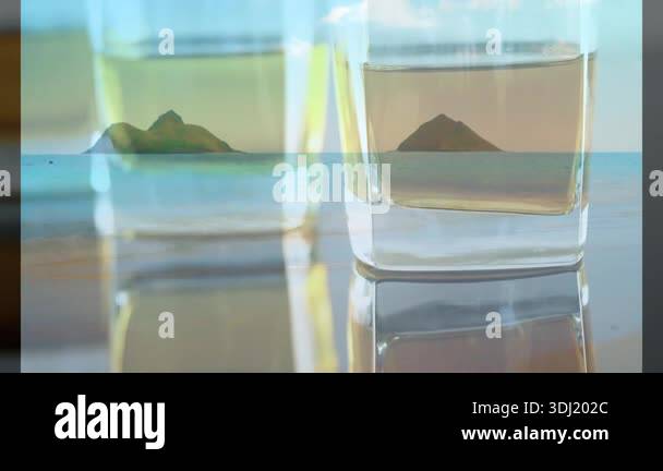 Shifting sunlight through two glass water tumblers casting highlights ...