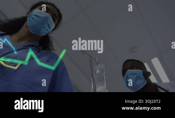 Nurse and doctor responding to animated ECG graph overlay in hospital ...