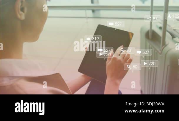 Woman transit lounge tapping tablet showing social media icons tracking ...