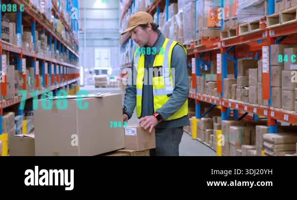 Warehouse worker lifting carton reading label writing details with ...