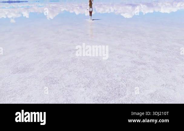 A woman running across the expansive Salar de Uyuni salt flats in ...