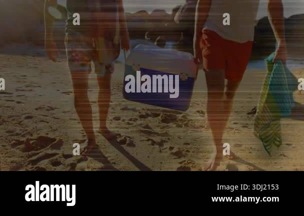 Grasping cooler two friends walking along beach carrying refreshments ...
